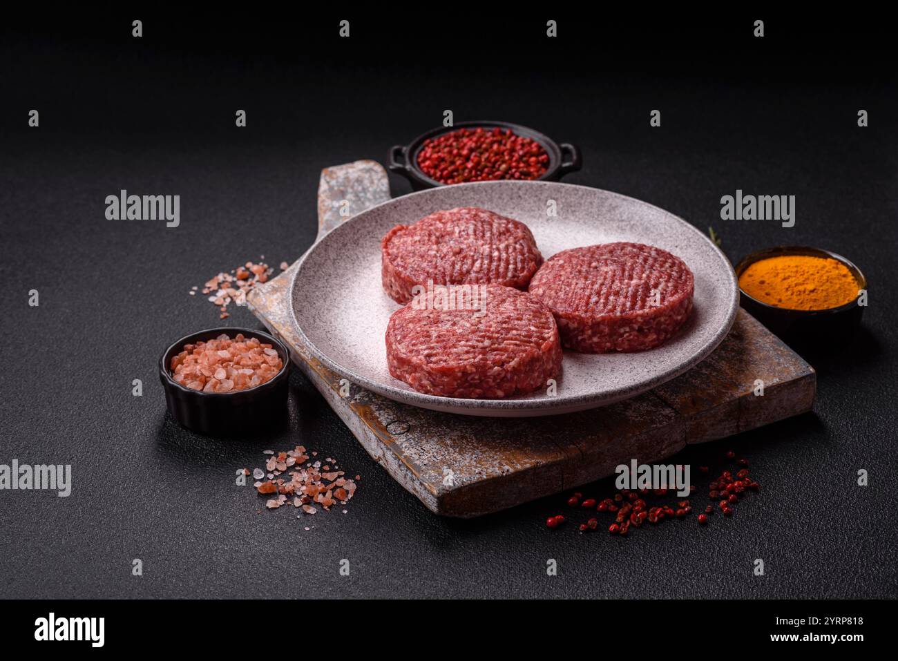 Fresh raw ground beef burger patty with salt and spices on textured ...