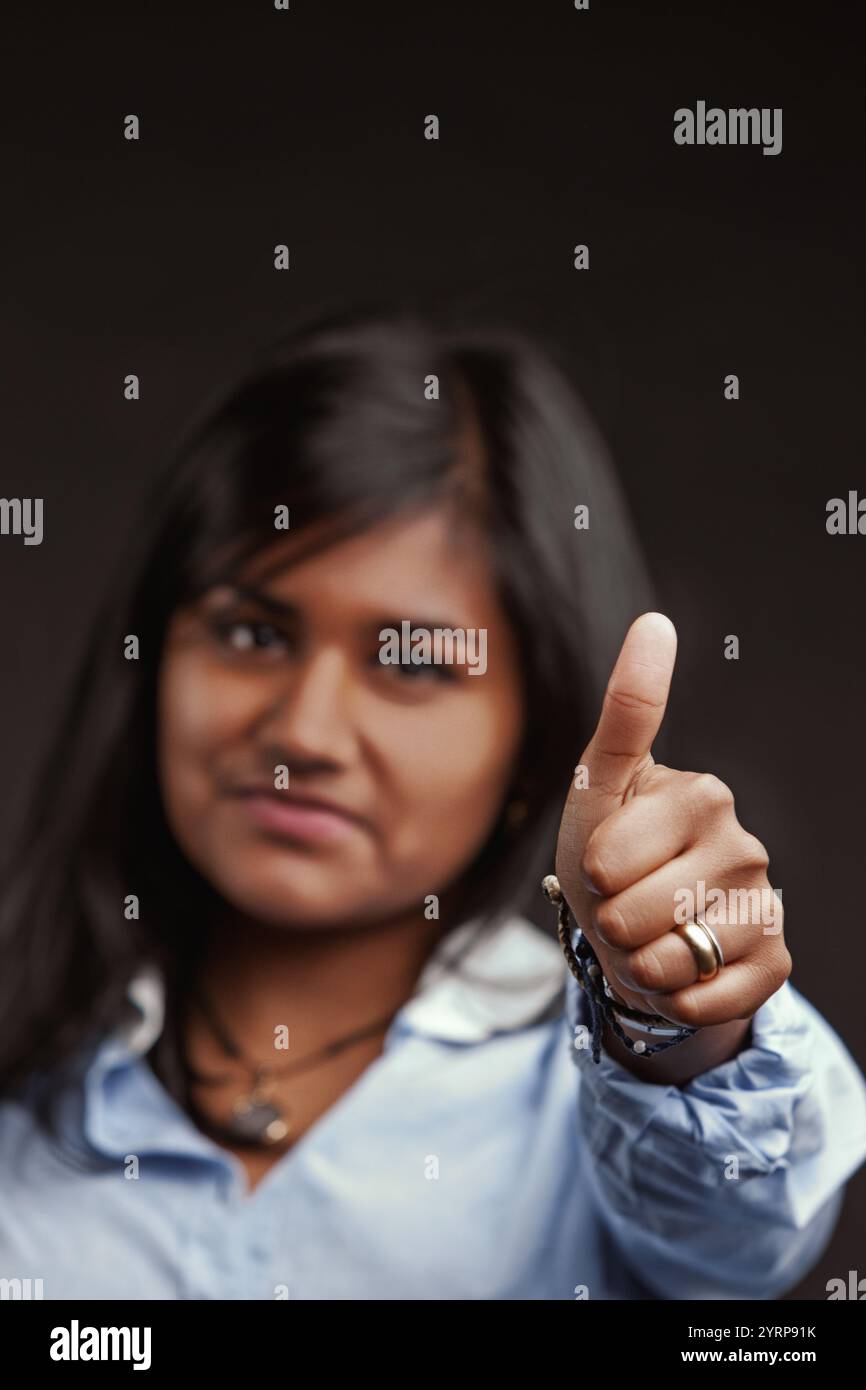 Young indian businesswoman expressing mixed feelings while showing a ...