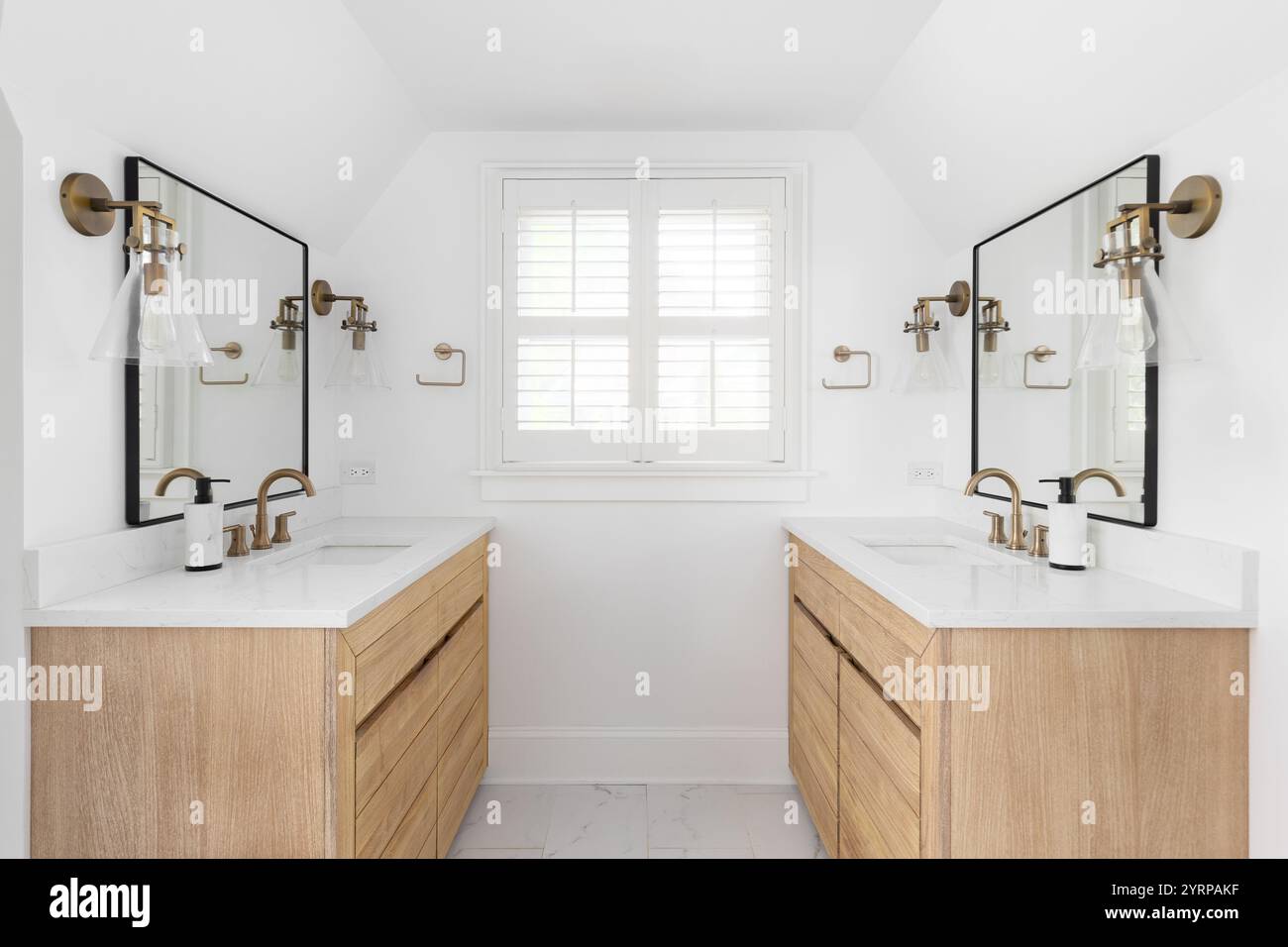 A bathroom with natural white oak cabinets, white marble countertops ...