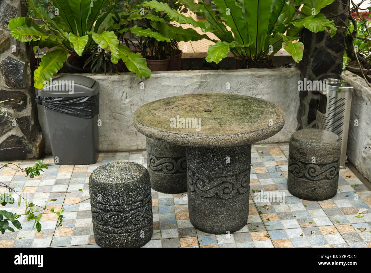 Stone table and stools in garden setting Stock Photo - Alamy