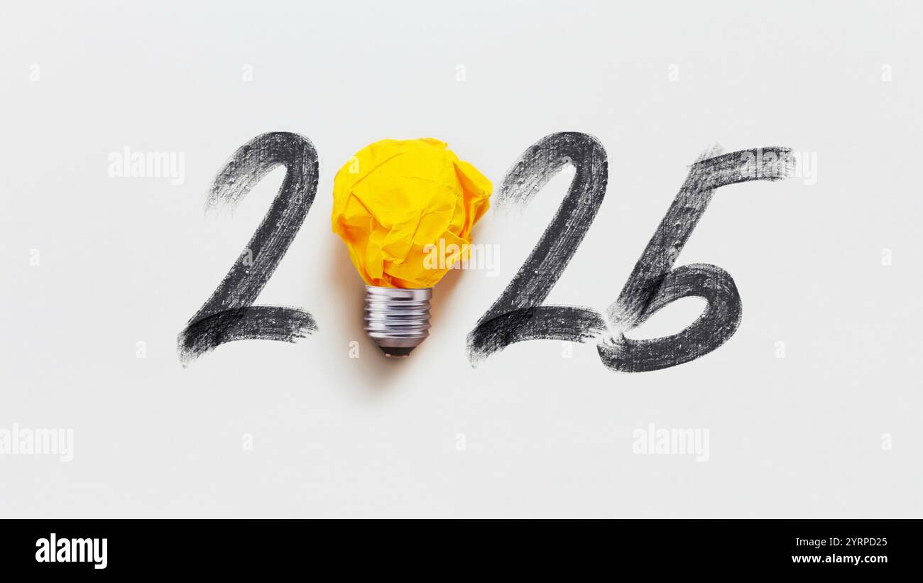 Creative 2025 New Year with light bulb yellow crumpled paper on white ...