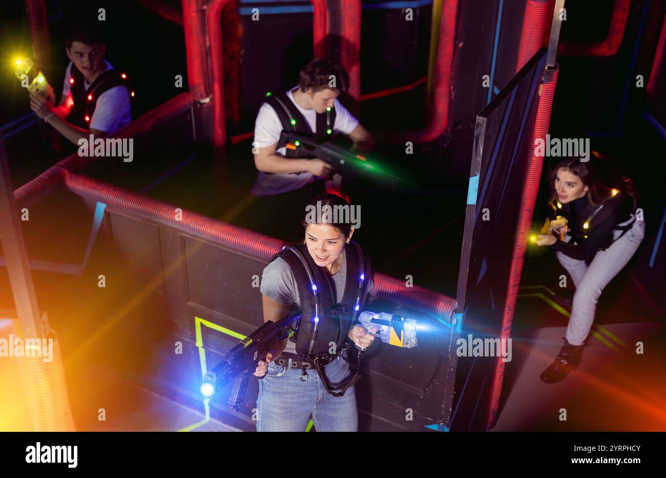 Laser tag players positive smiling guys and girls playing in teams in ...