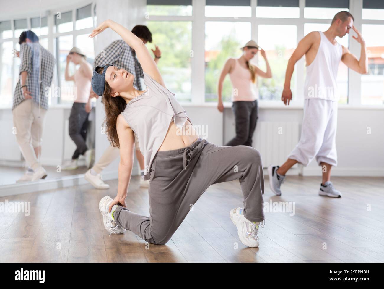 Girl poses against background of hip hop dancing people Stock Photo - Alamy