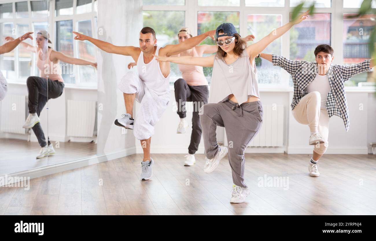 Active men and girls practicing hip-hop dance in training hall during ...