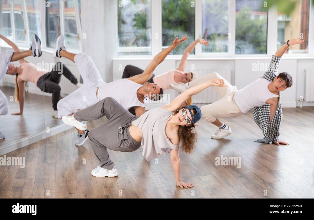Girl and her students perform hip hop dance on one bent leg, movement ...