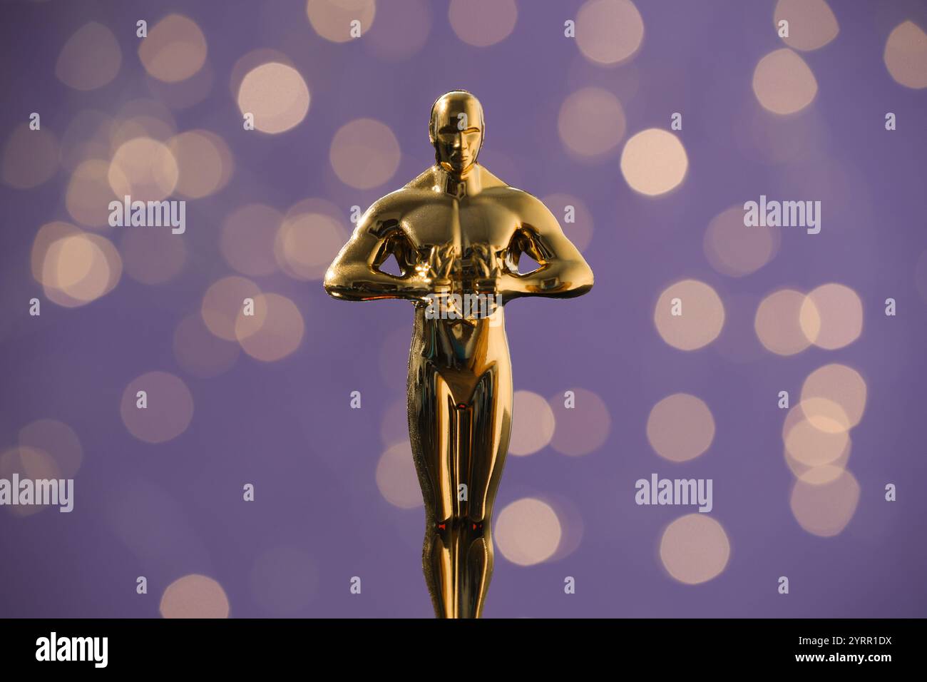 Golden trophy in shape of human figure on purple background with ...