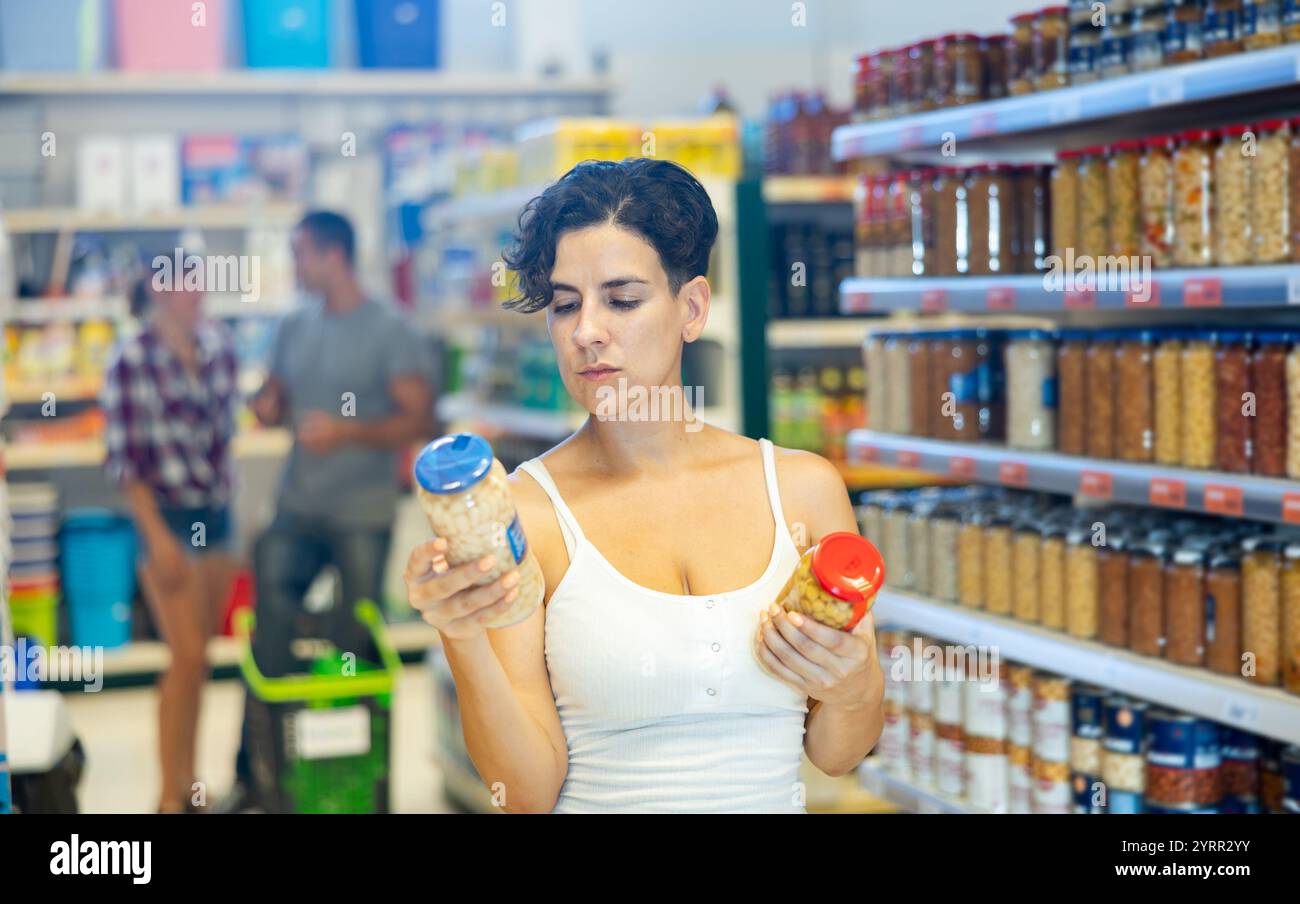 Woman selecting pickled products in grocery store Stock Photo - Alamy