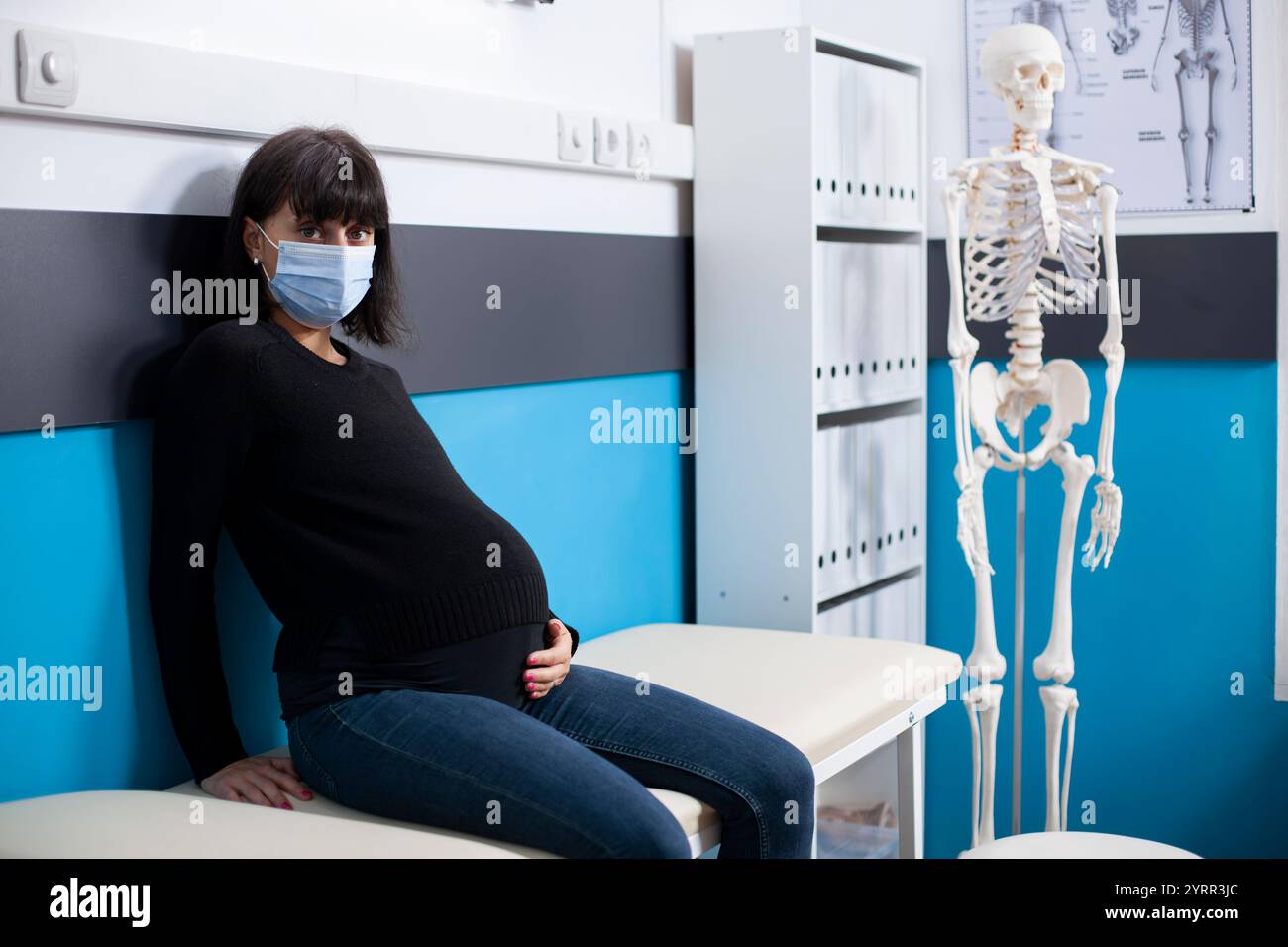 Pregnant caucasian patient wearing casual clothing in clinic room ...