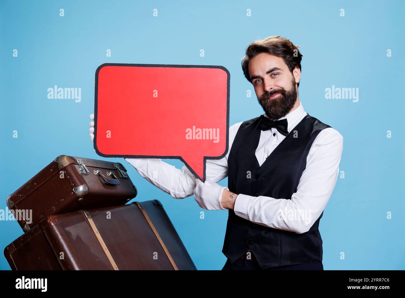Hotel employee presenting ad with speech bubble, posing with red ...