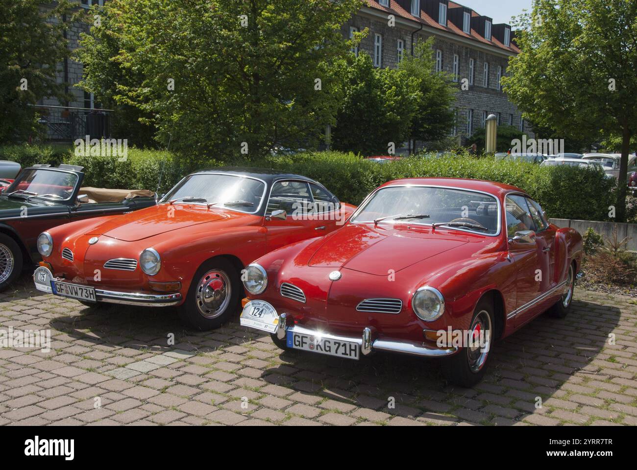 Two red Karmann Ghia vintage cars standing next to each other on a ...