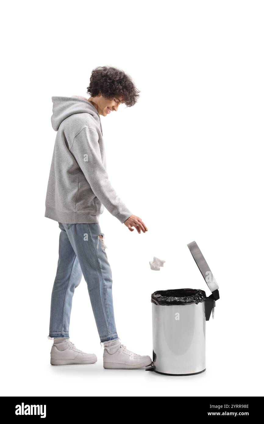 Young man throwing paper in a bin isolated on white background Stock ...