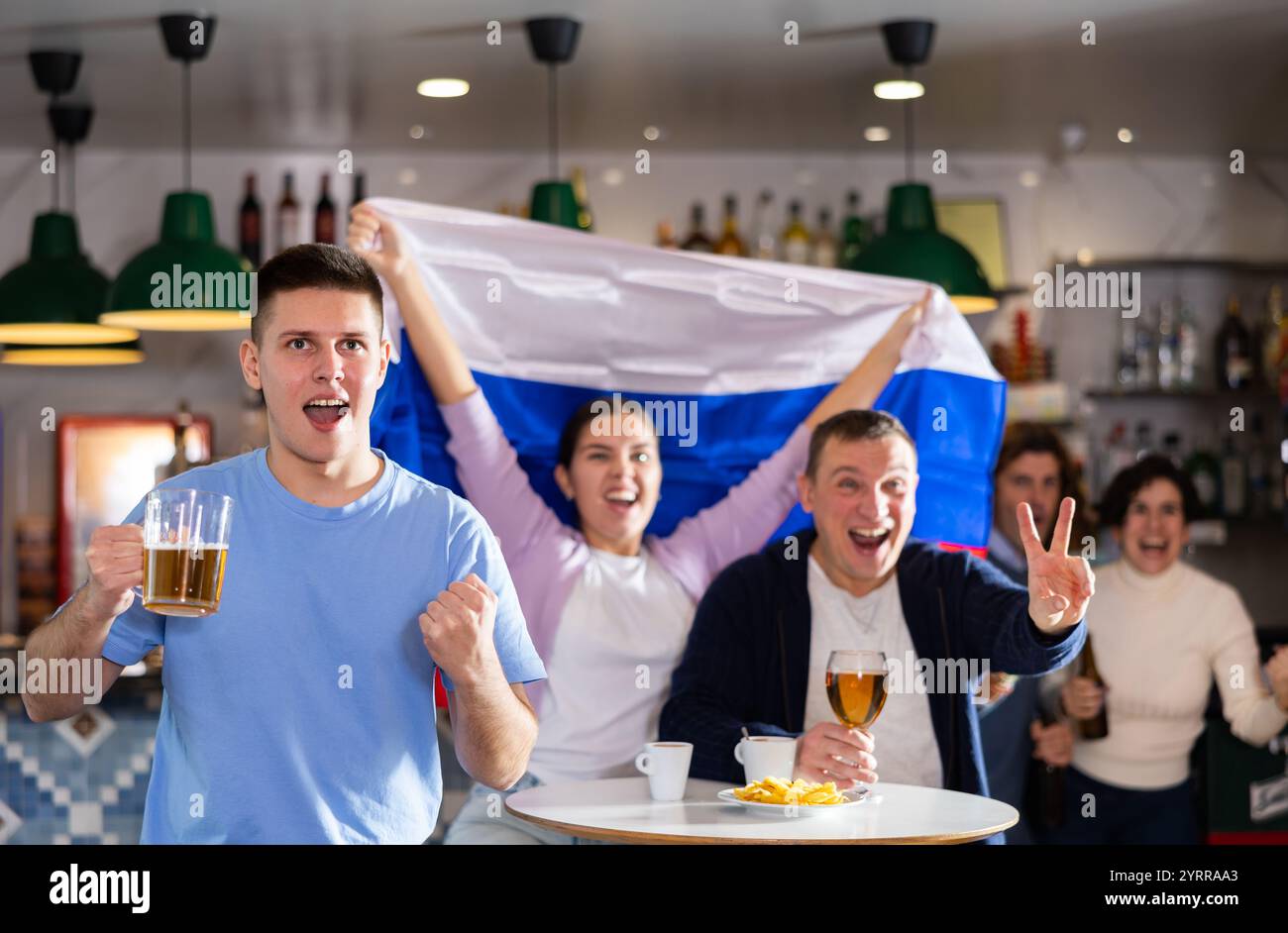 Emotional young adult sports fans supporting Russian team with flag ...