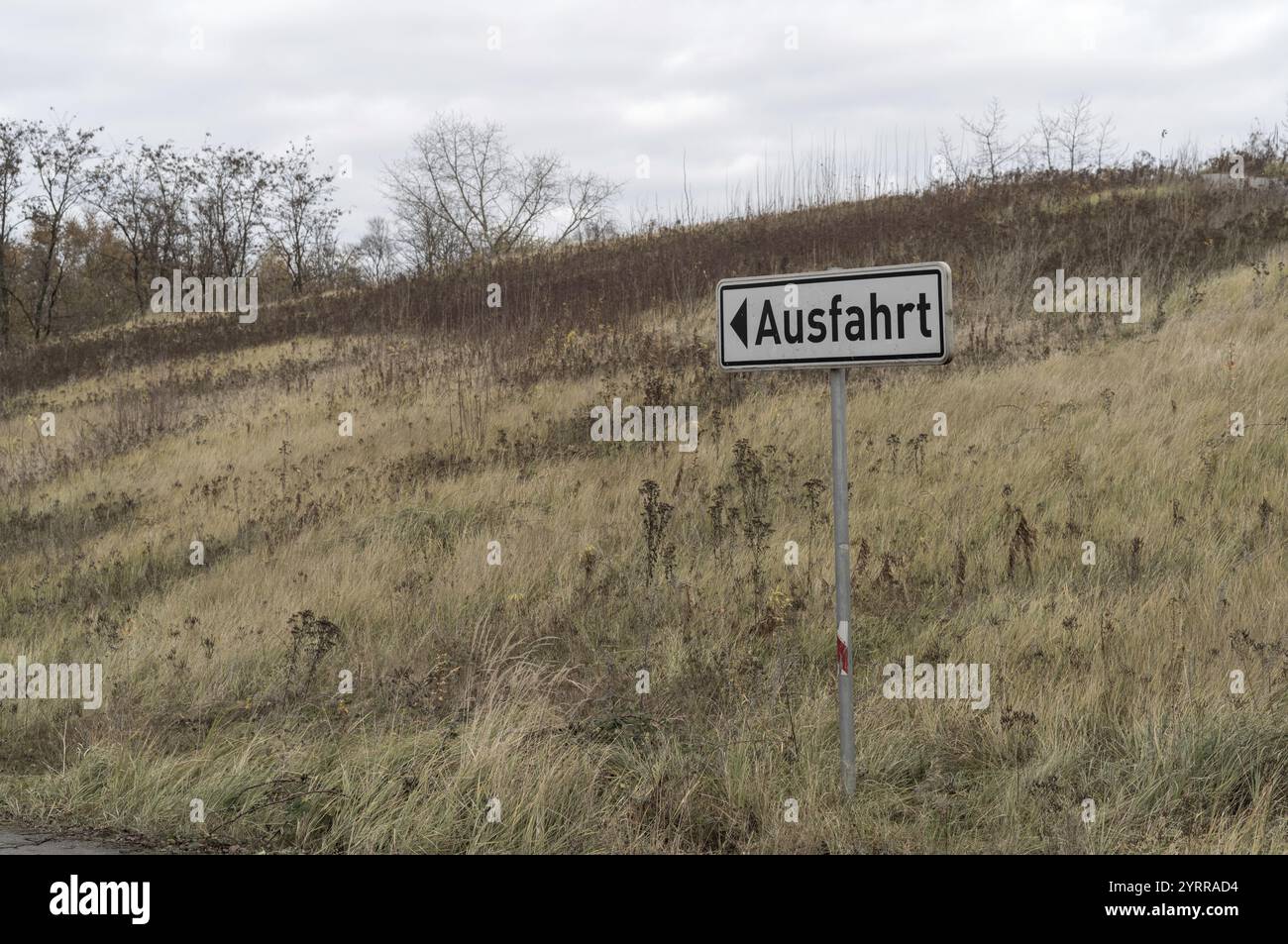 German exit sign pointing the way out of a dry grassy field in autumn ...