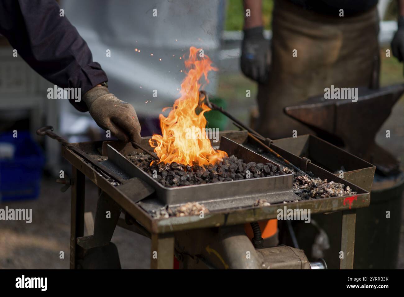 Blacksmith stokes the fire Stock Photo - Alamy