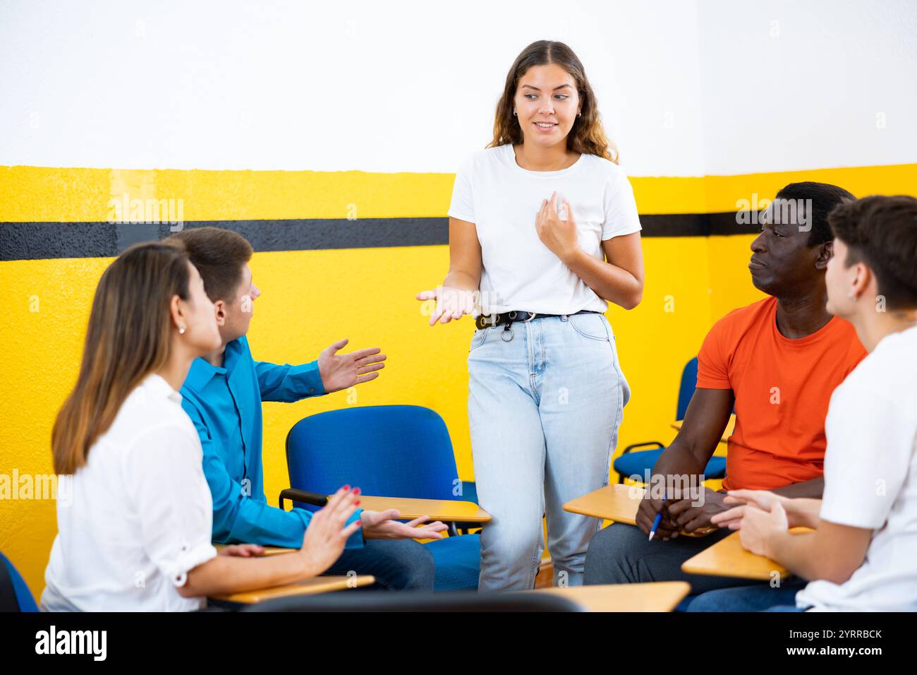 Girl talking to student group during brainstorming while preparing for ...