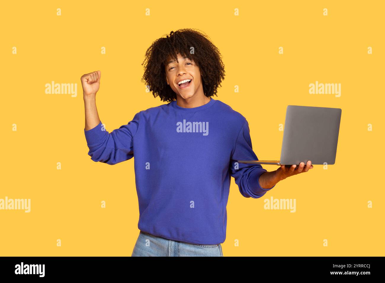 Joyful Brazilian man celebrates success while working on a laptop Stock ...
