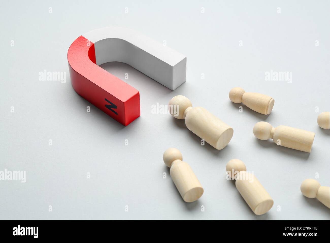Magnet attracting human figures on light grey background, closeup Stock ...