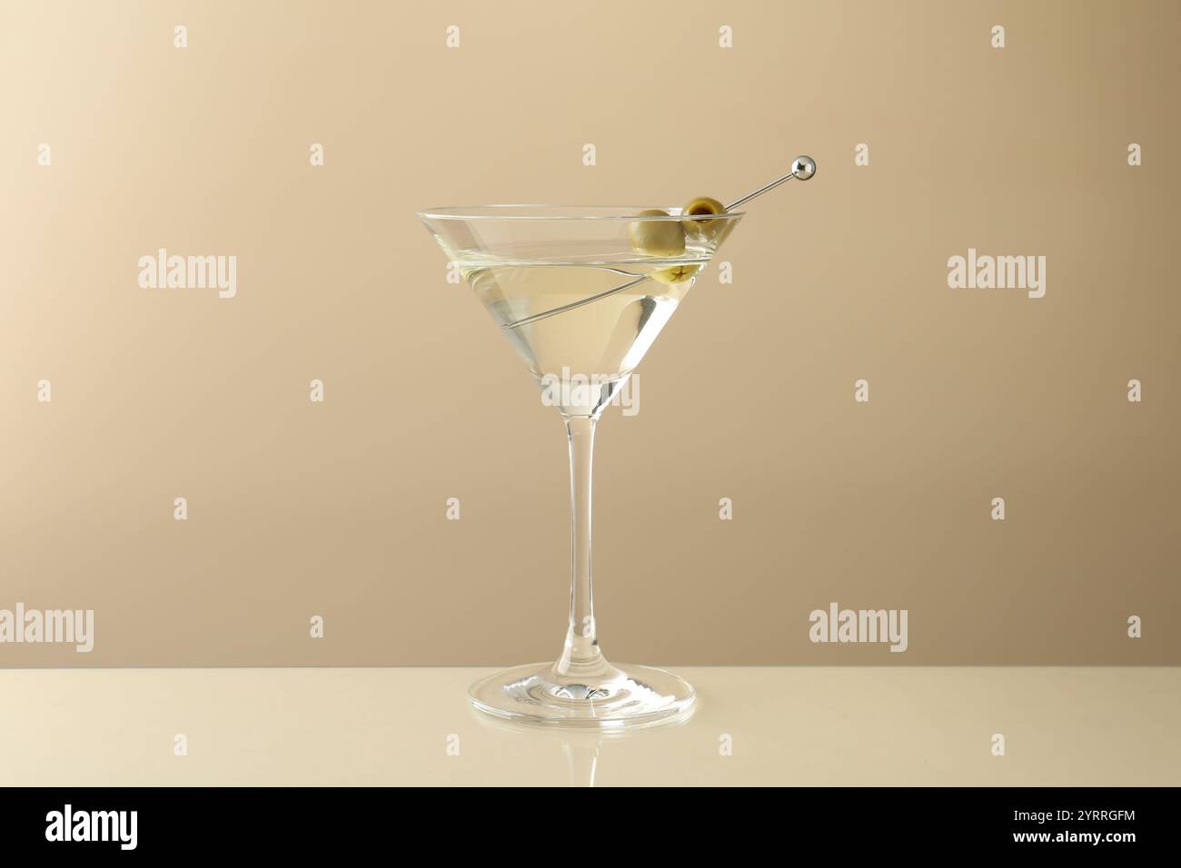 Martini cocktail with olives in glass on beige table Stock Photo - Alamy