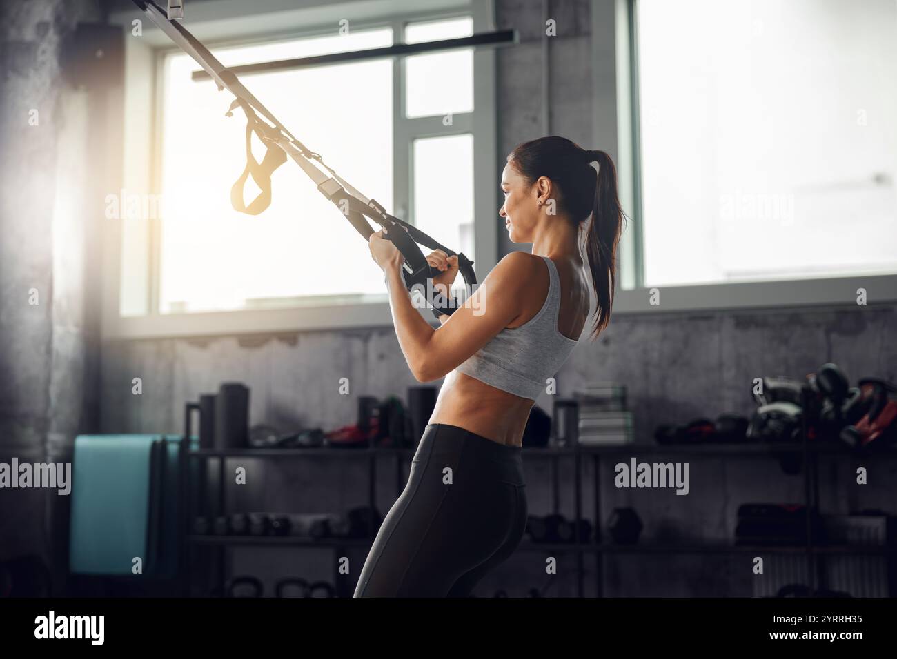 Fitness enthusiast using TRX training in a gym to enhance performance ...