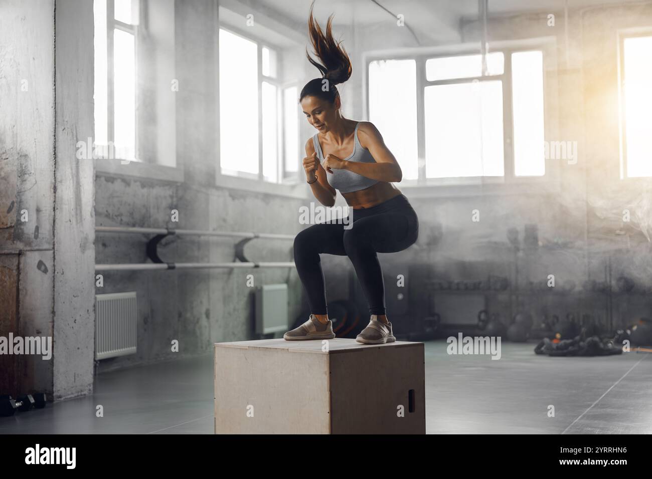 A Dynamic Woman Engaging in the Box Jump Exercise Within a Gym ...