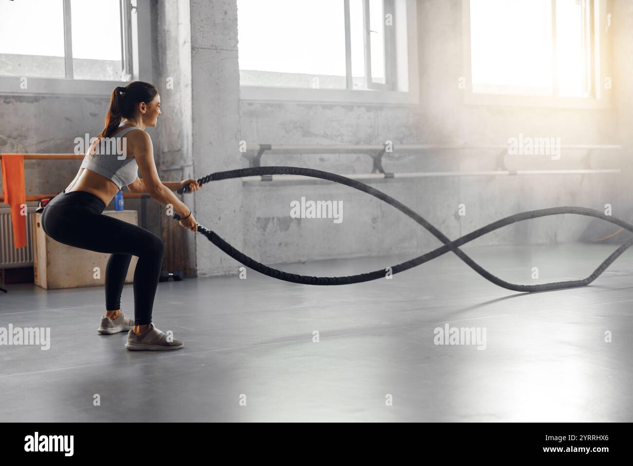Engaging in a Dynamic Workout using Battle Ropes in a Modern Gym ...