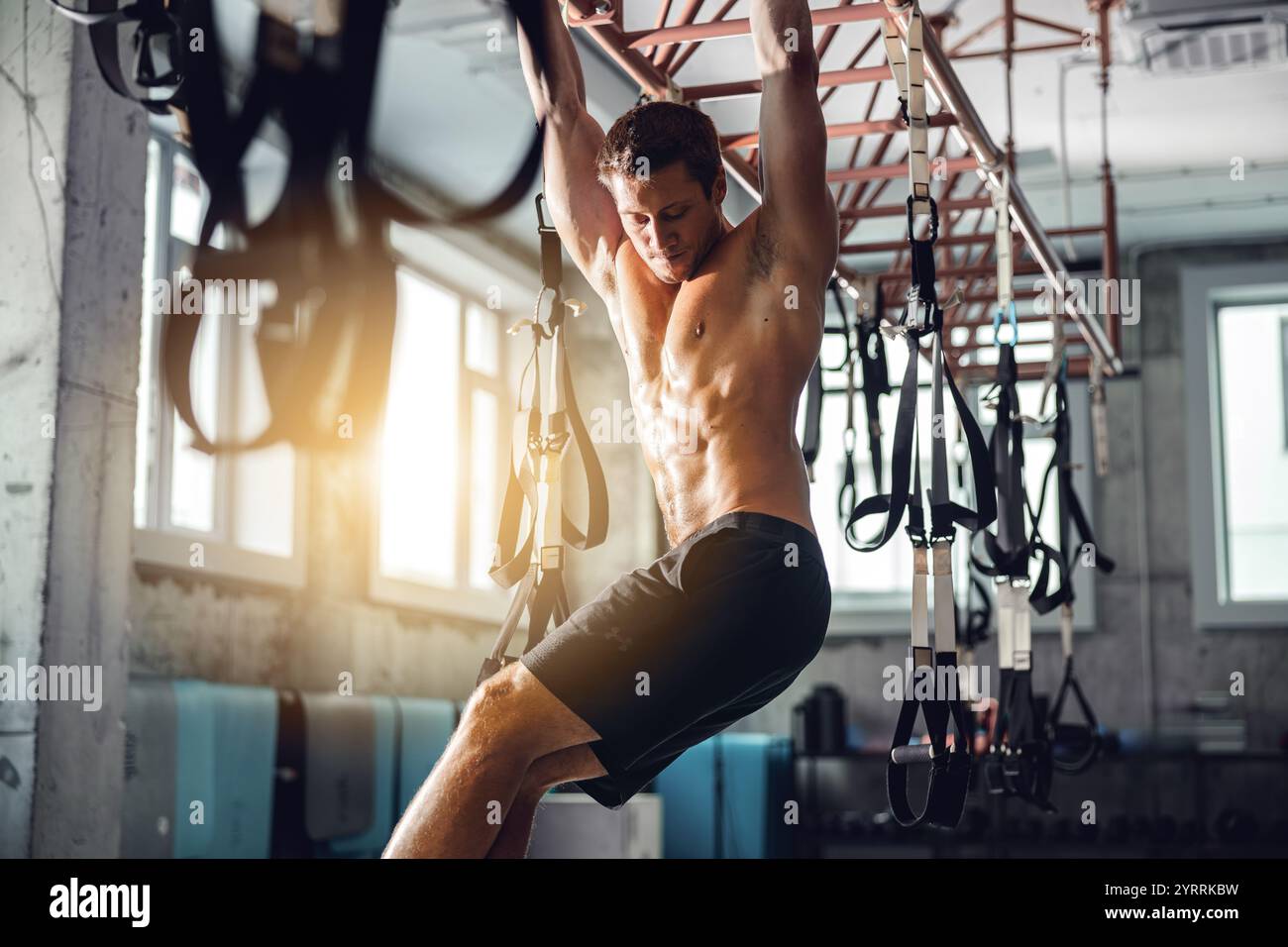 An athlete trains at a modern gym using TRX suspension equipment for ...