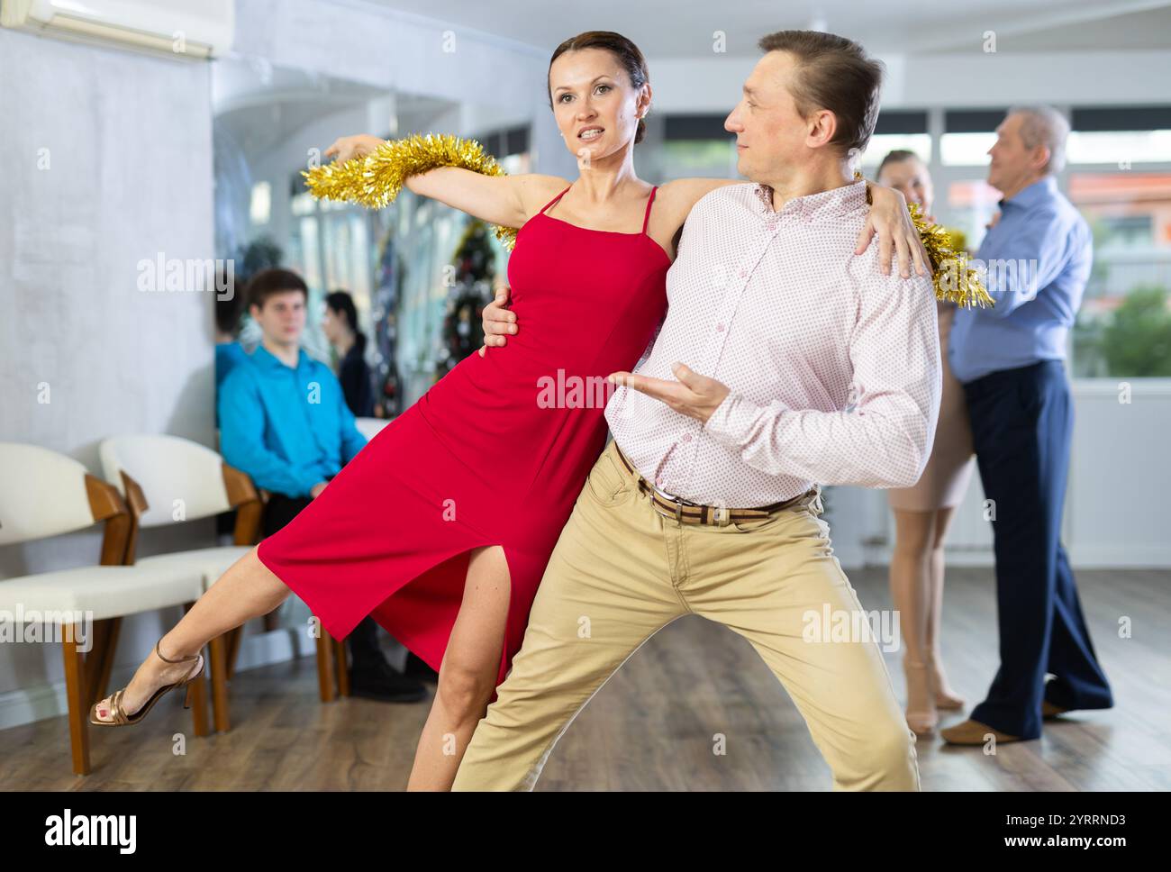 Man and woman performing support while dancing salsa at Christmas party ...