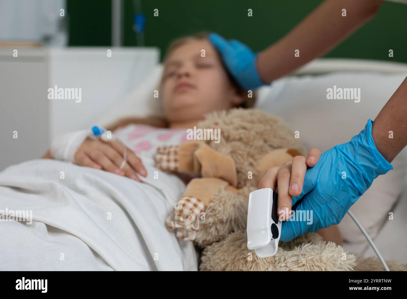 A sick child in a hospital is comforted by a teddy bear and a caring ...