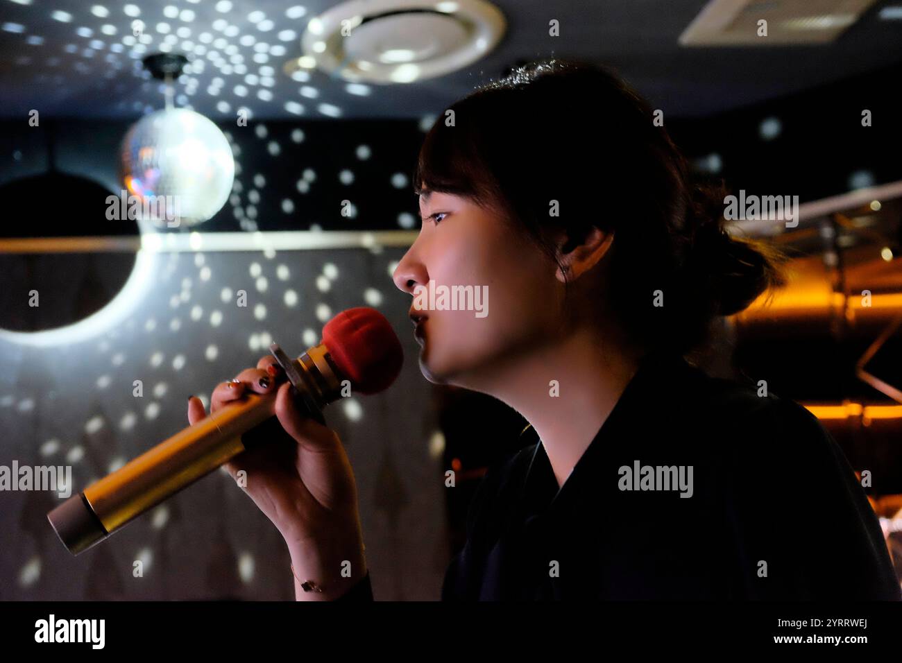 Woman singing holding microphone hi-res stock photography and images ...