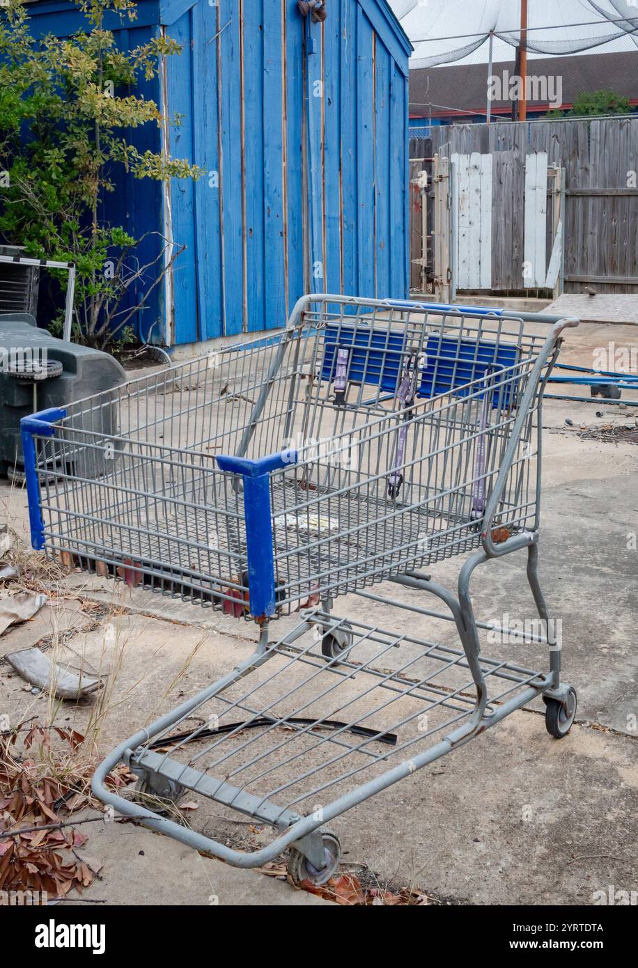 Old abandoned metal shopping cart next to an urban abandoned garbage dump. Photo taken in ...