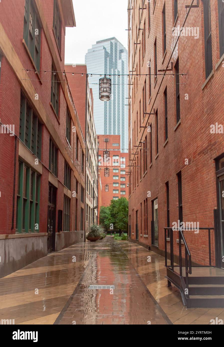 Red brick building alleyway leading to a skyscraper building. Photo ...