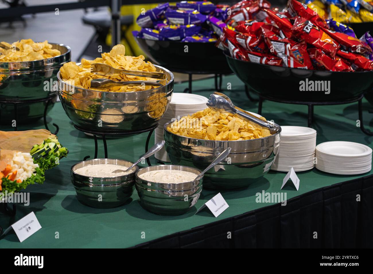 Large stainless steel bowls filled with crispy potato chips at a snack ...