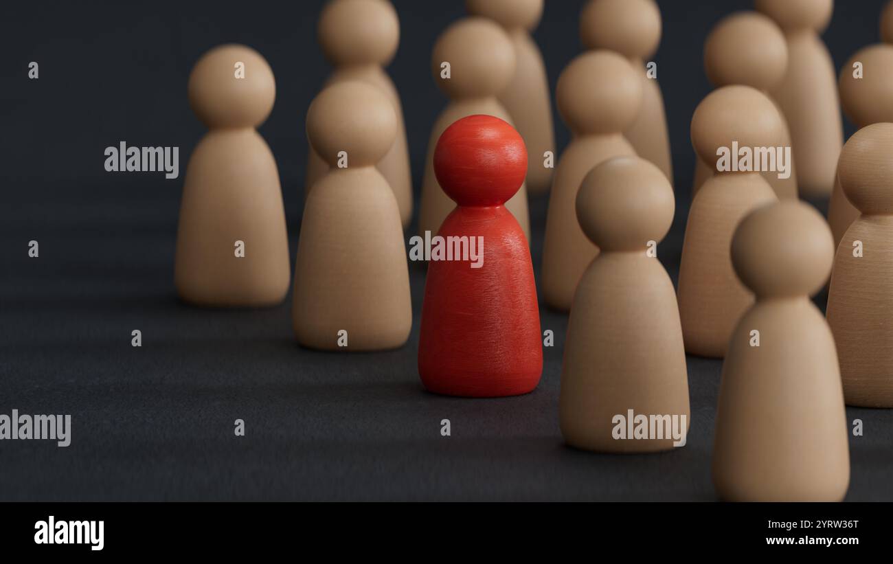 Red wooden figure standing in wood yellow team group to show influence ...
