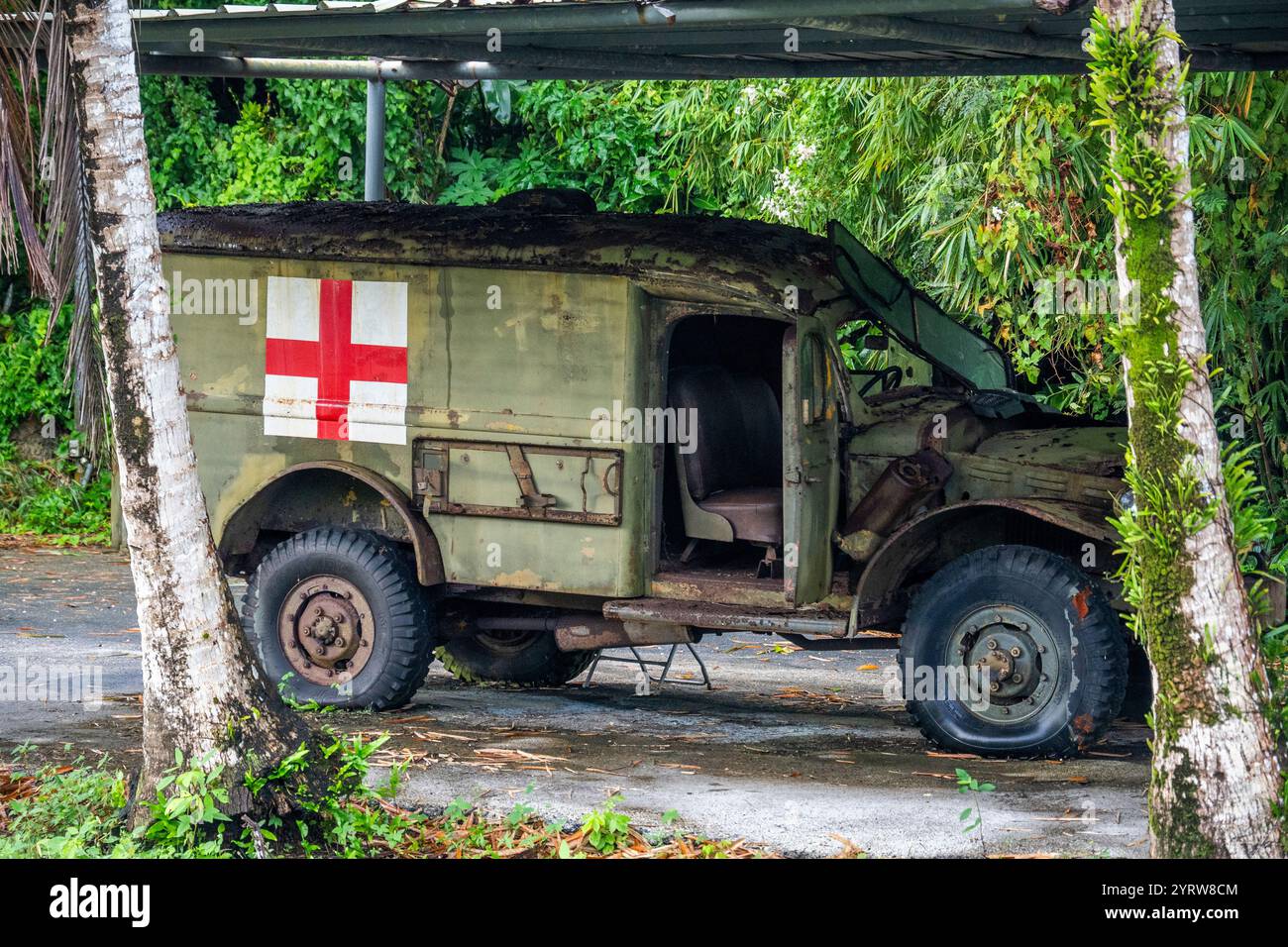 Old military ambulance parked under shelter in Guam's lush greenery ...