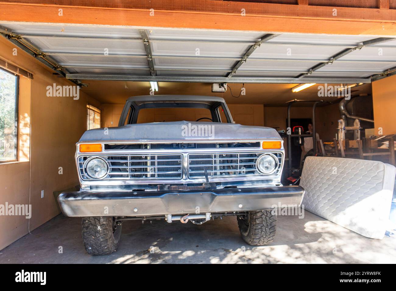 Classic Ford highboy truck parked in a rustic garage during daylight ...