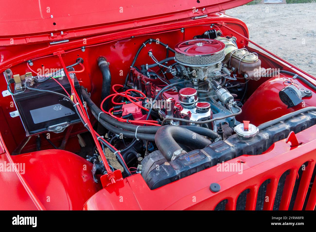 Detailed view of a classic car engine with vibrant red paint and chrome ...