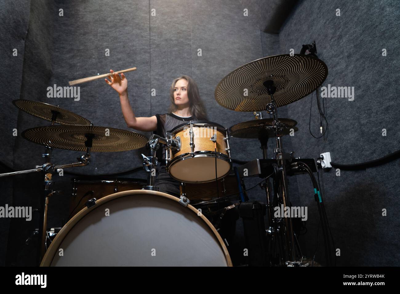 Woman performing with drumsticks in soundproof studio. Female drummer ...