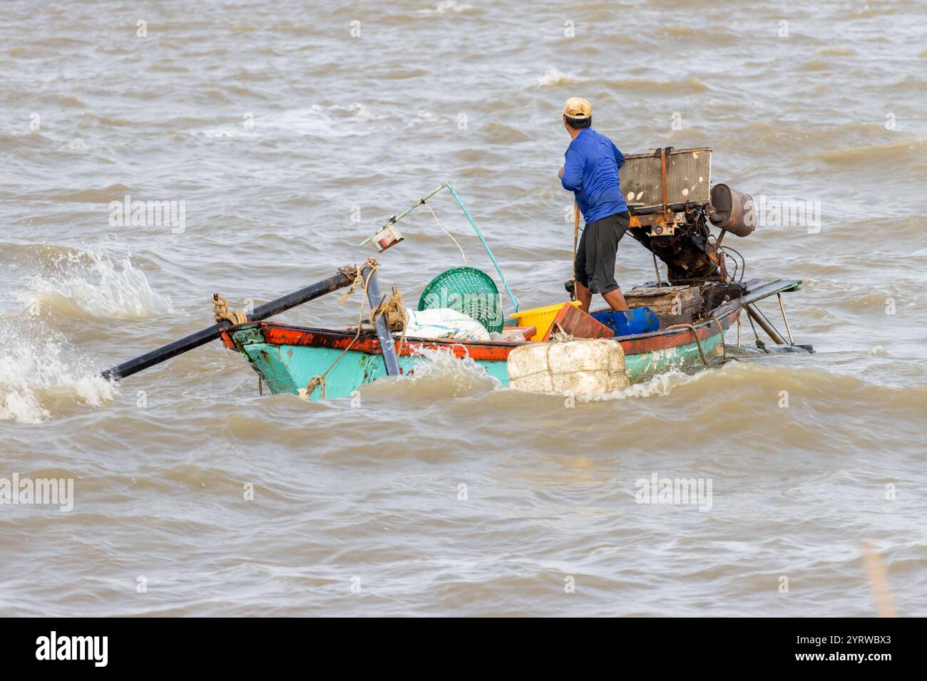 A fisherman on a boat catches fish Stock Photo - Alamy