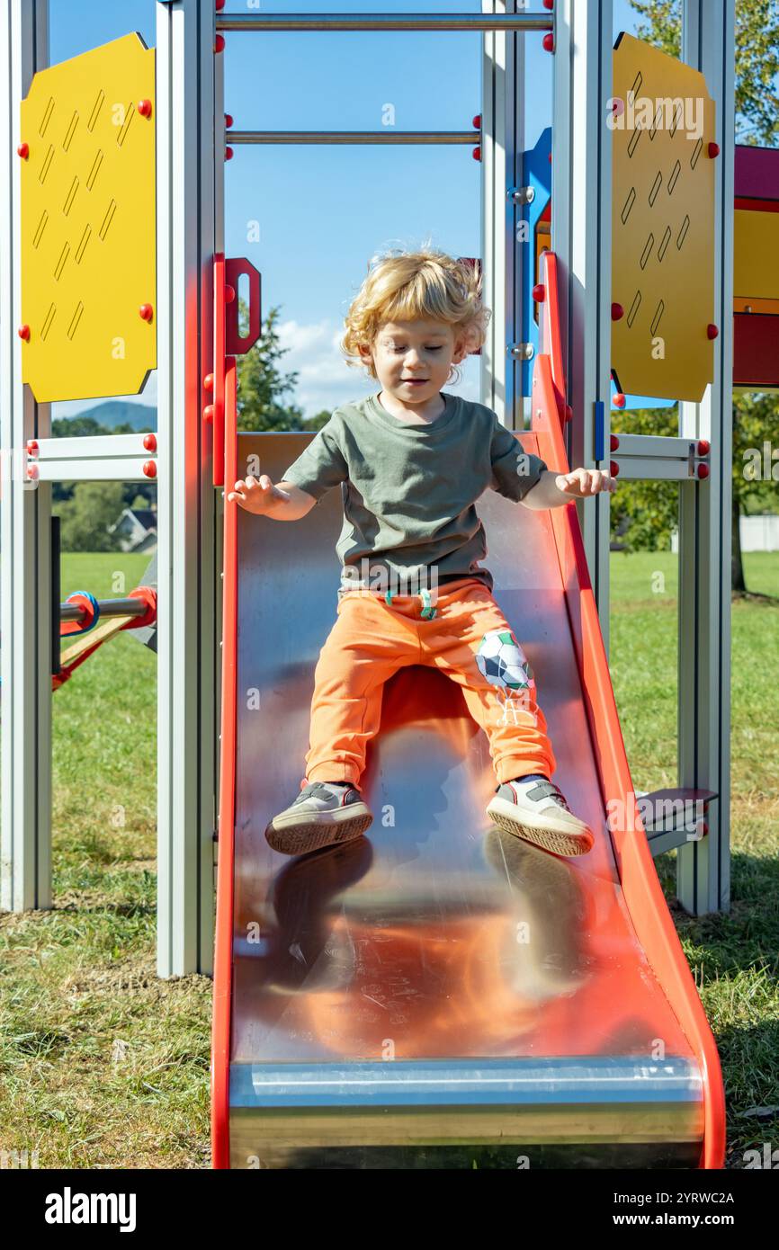 A little boy is sliding on a slide Stock Photo - Alamy