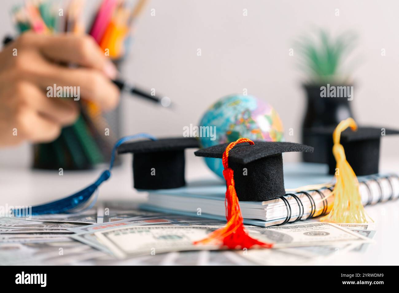 University graduate, holding their diploma and wearing cap and gown ...