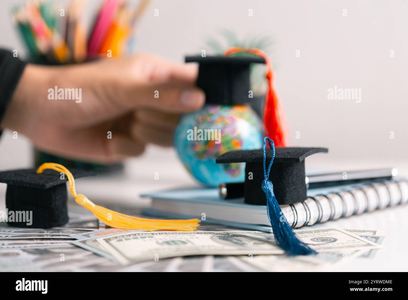 University graduate, holding their diploma and wearing cap and gown ...