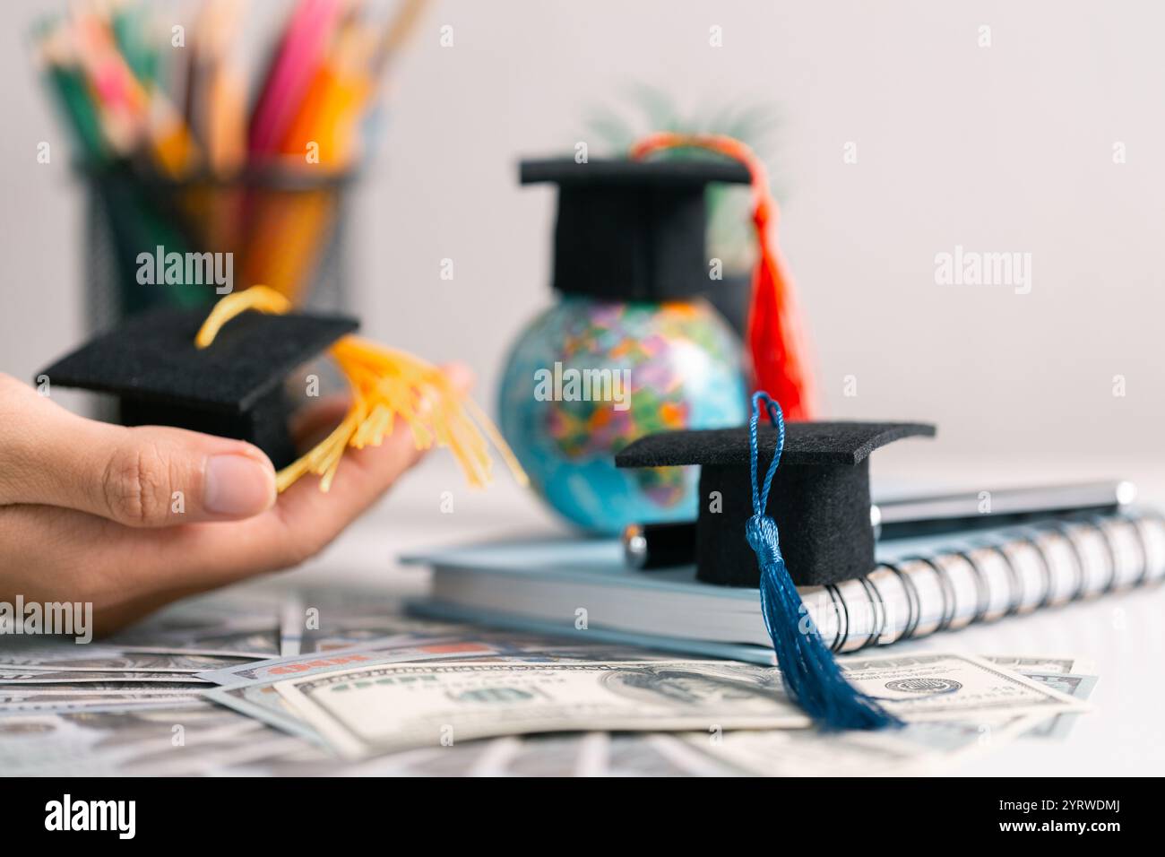 University graduate, holding their diploma and wearing cap and gown ...