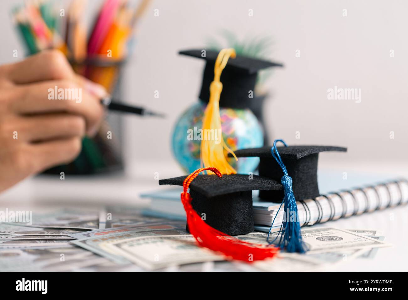 University graduate, holding their diploma and wearing cap and gown ...