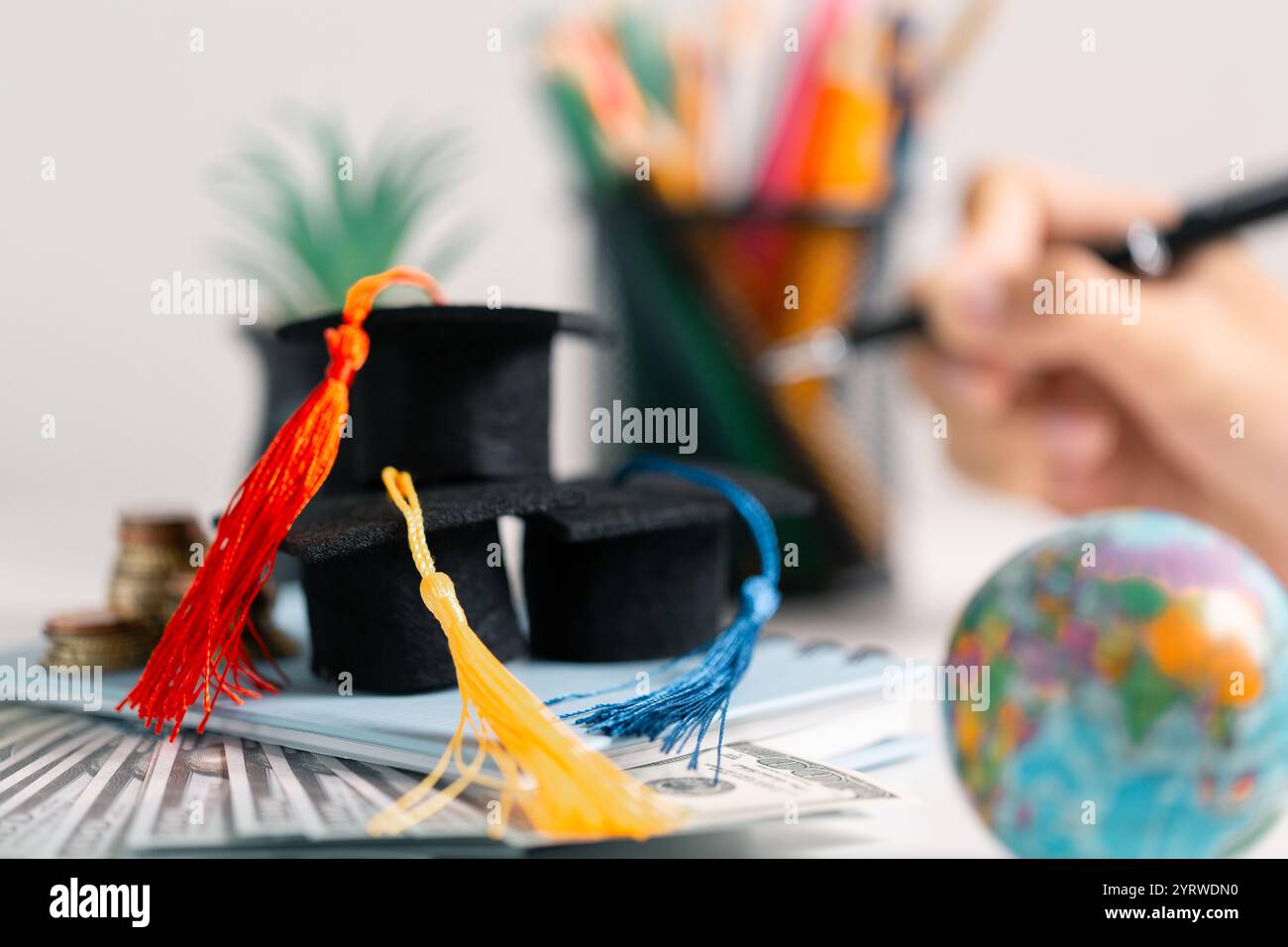 University graduate, holding their diploma and wearing cap and gown ...