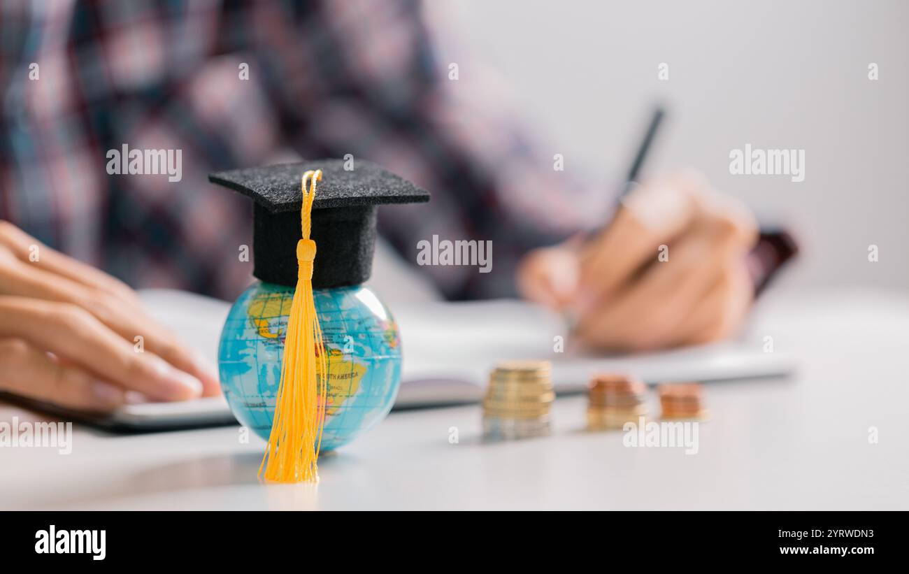 University graduate, holding their diploma and wearing cap and gown ...