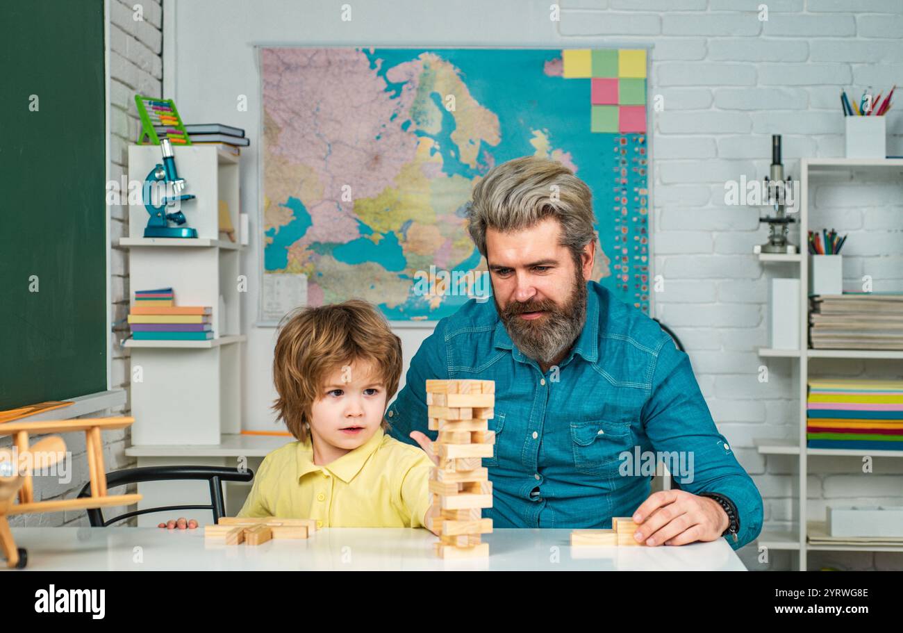 Children building wood blocks at home. Father and son playing stacking ...