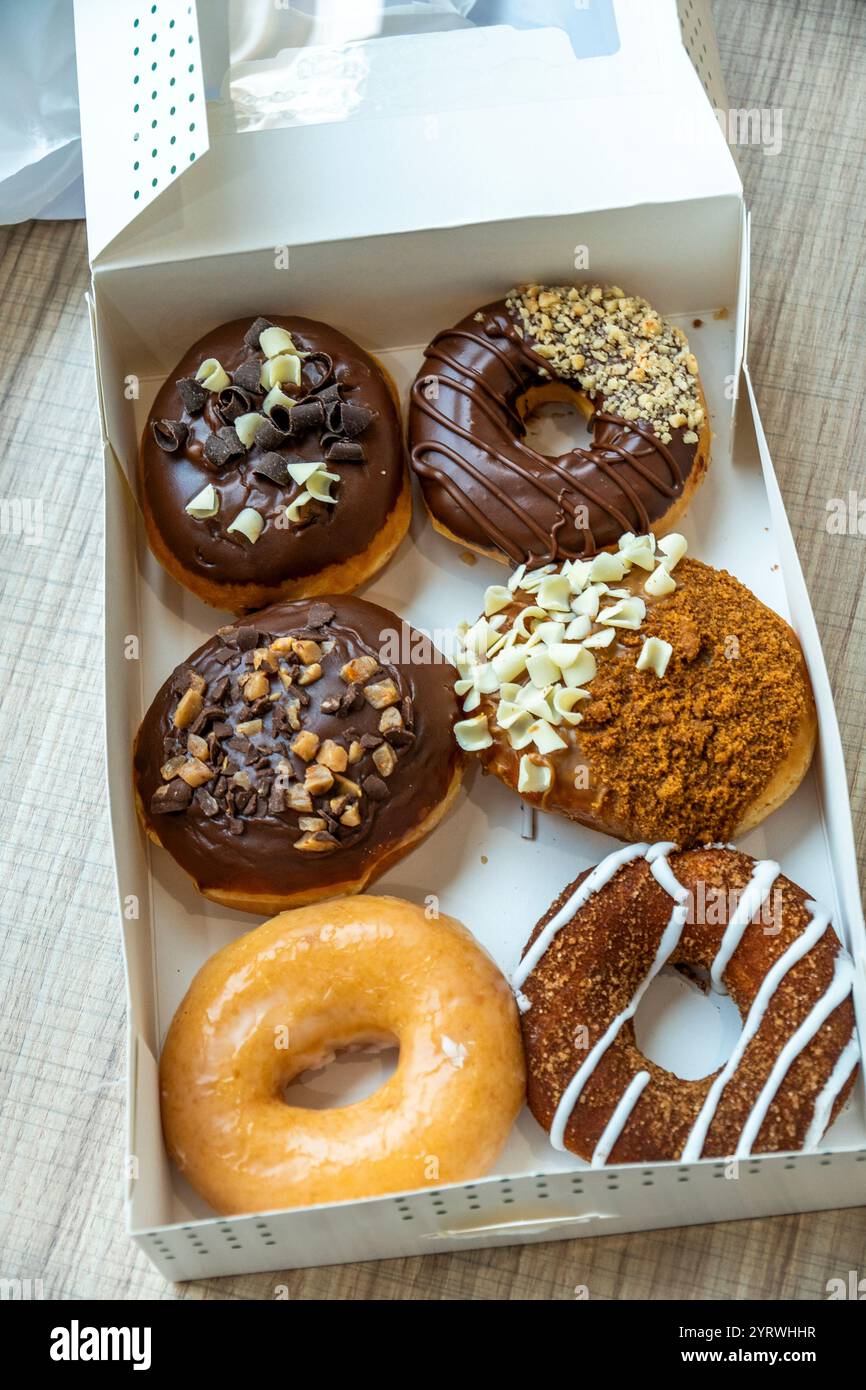 Variety of delicious donuts in a box ready for sharing at a gathering ...