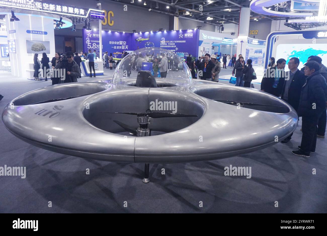 Visitors look at a manned flying saucer electric vertical Take-off and ...