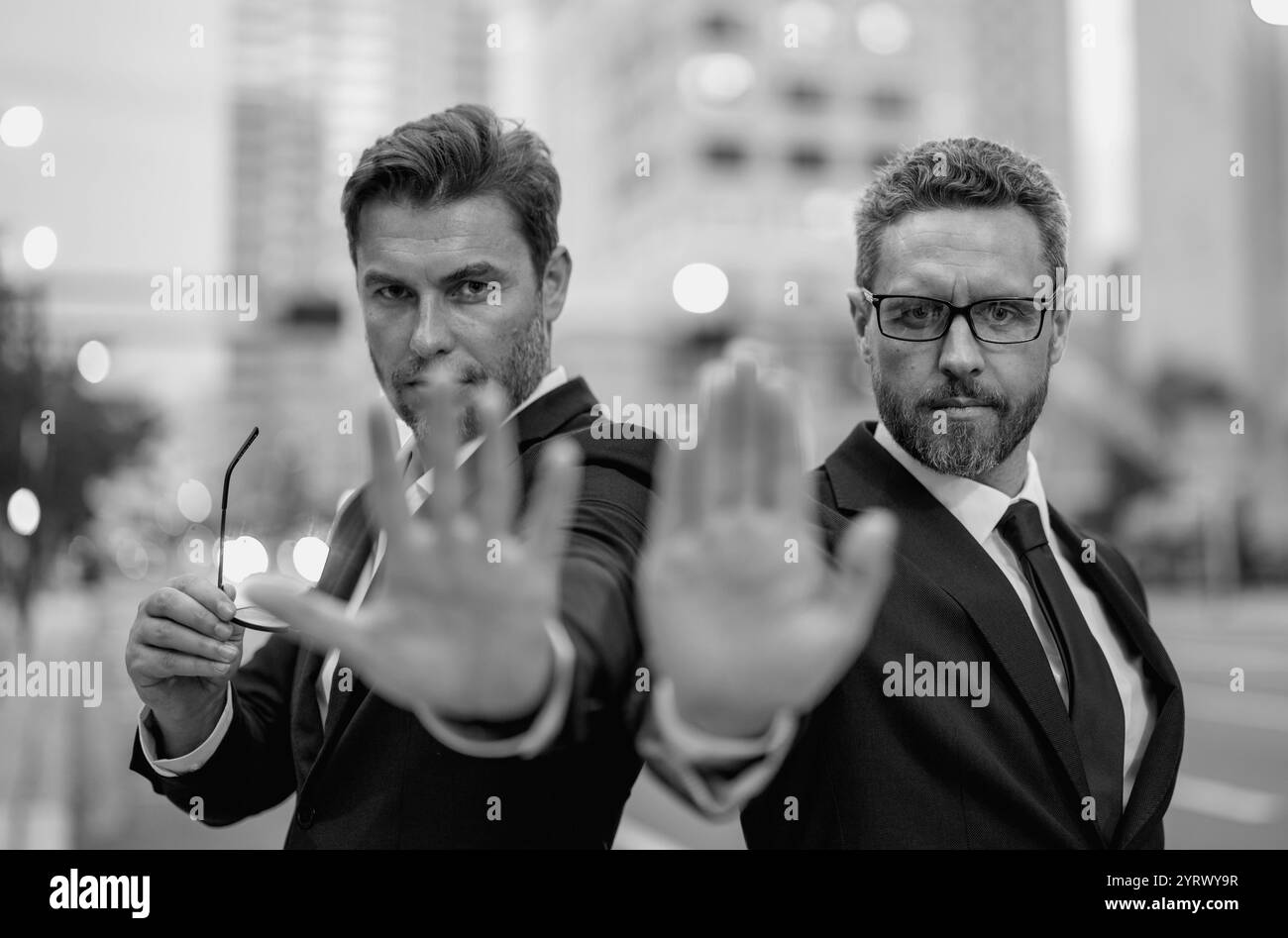 Crisis, risk. Two handsome business men in suit doing stop sing with ...