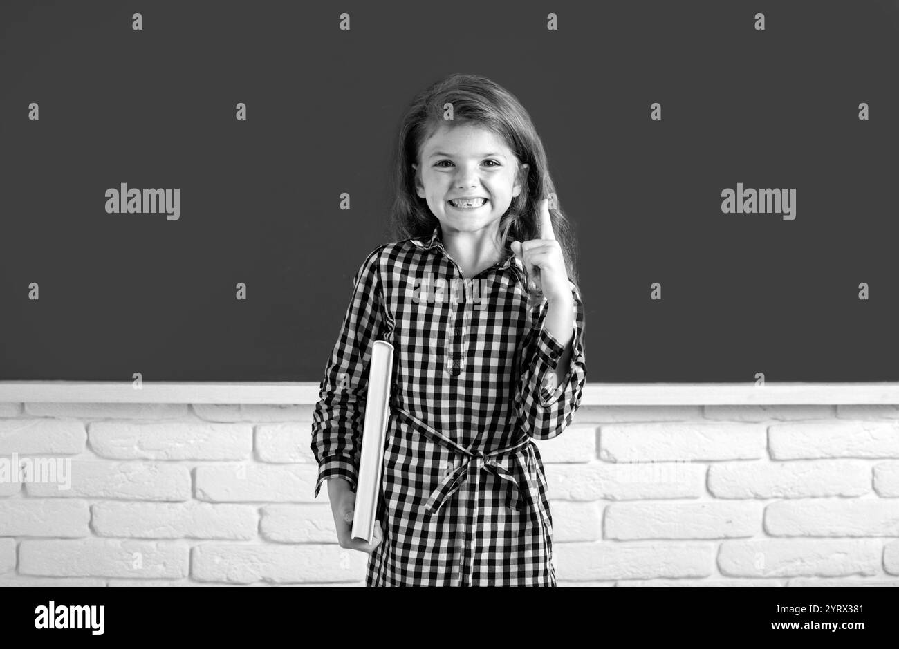 School girl with pointing finger studying math on lesson in classroom ...